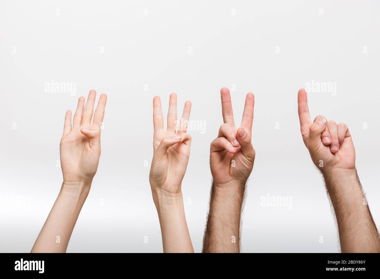 Closeup photo of a man's and woman's hands isolated over white wall ...