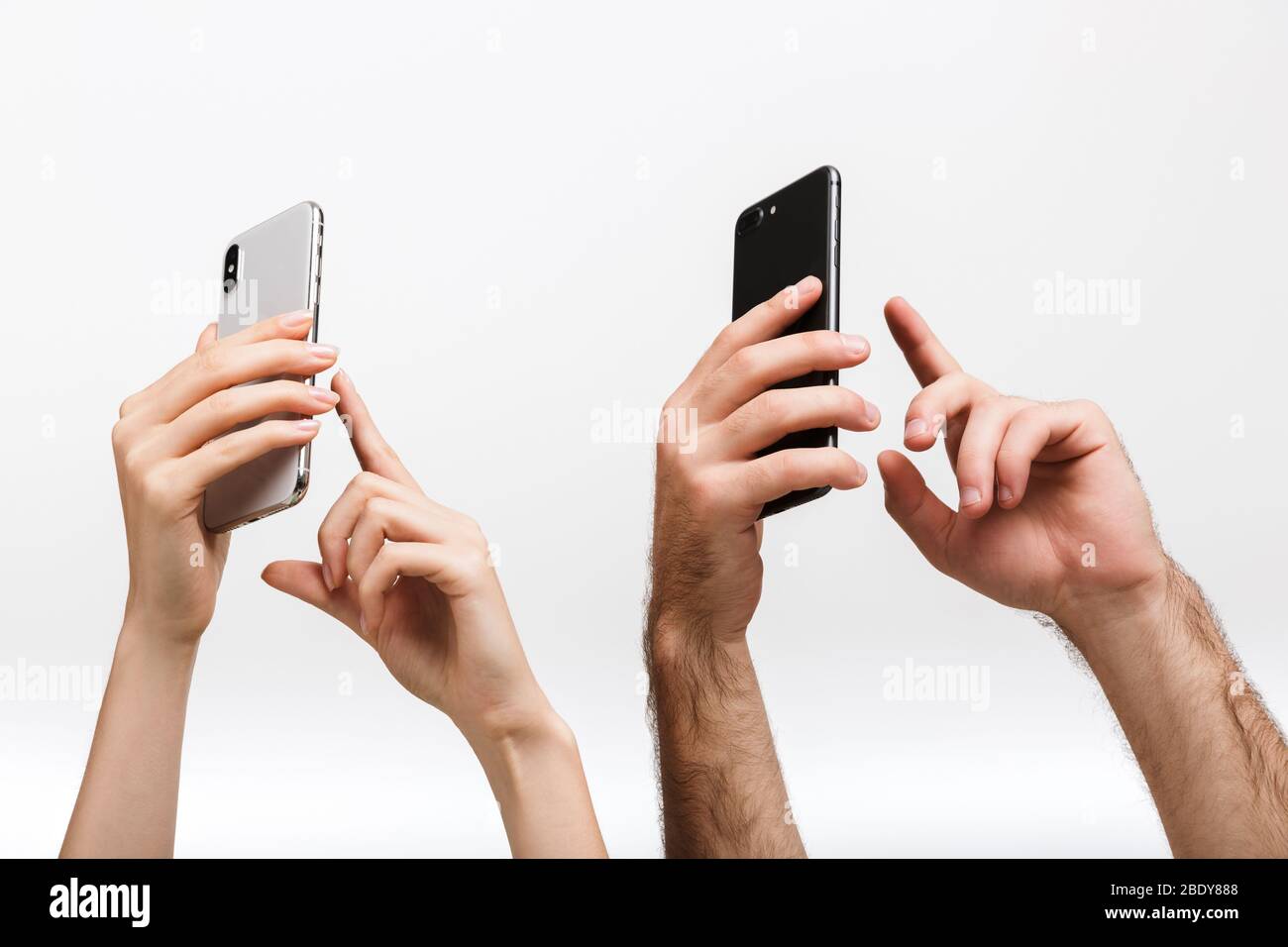 Closeup photo of a man's and woman's hands isolated over white wall ...