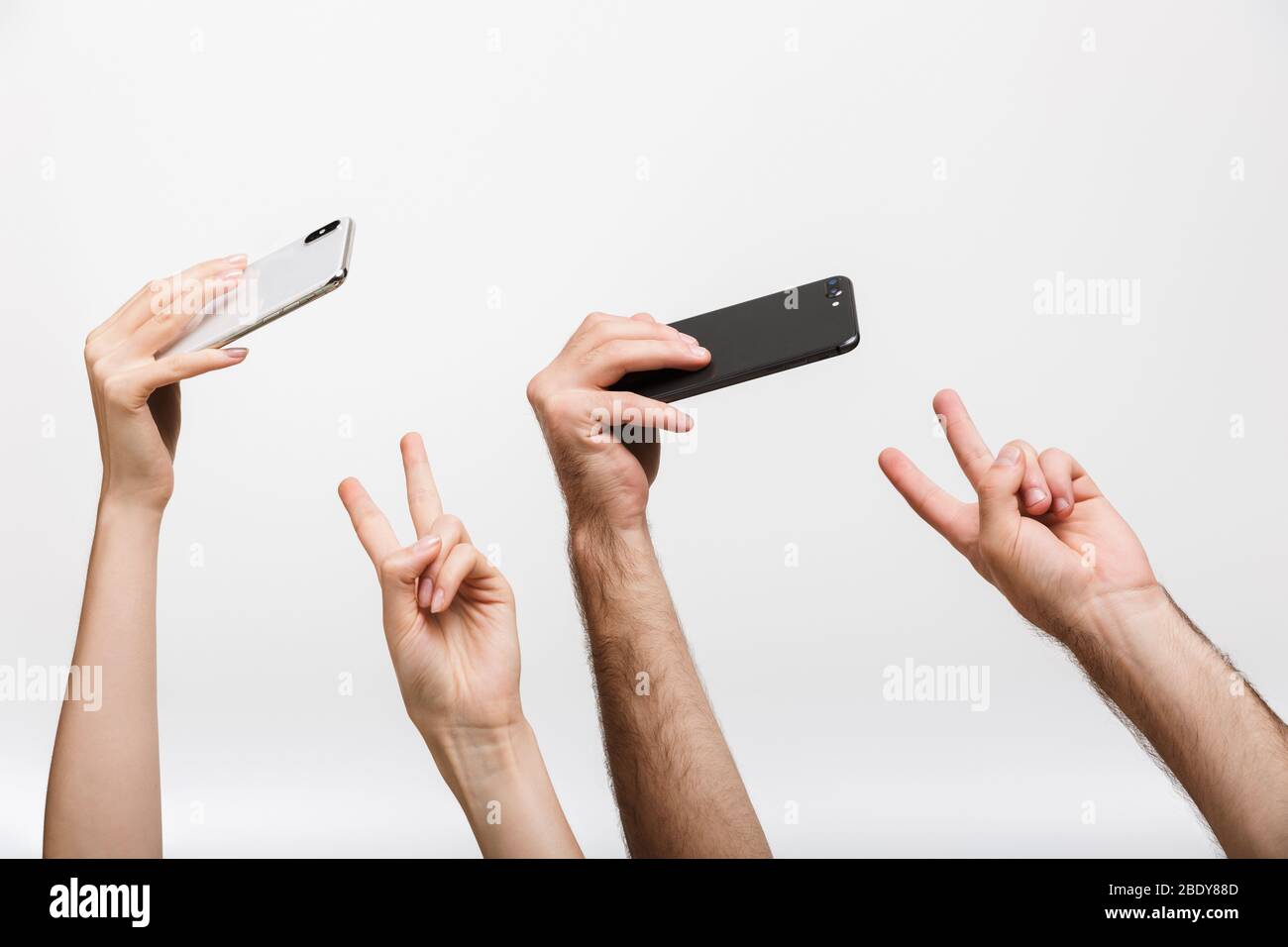 Closeup image of a man's and woman's hands isolated over white wall ...