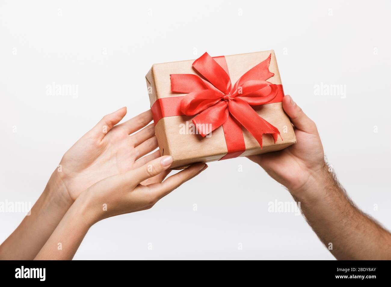 Closeup picture of a man's and woman's hands isolated over white wall ...