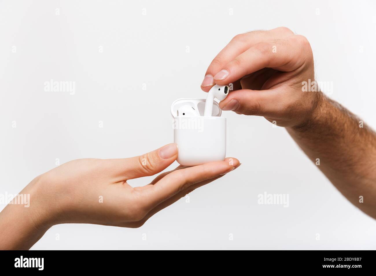 Closeup image of a man's and woman's hands isolated over white wall ...