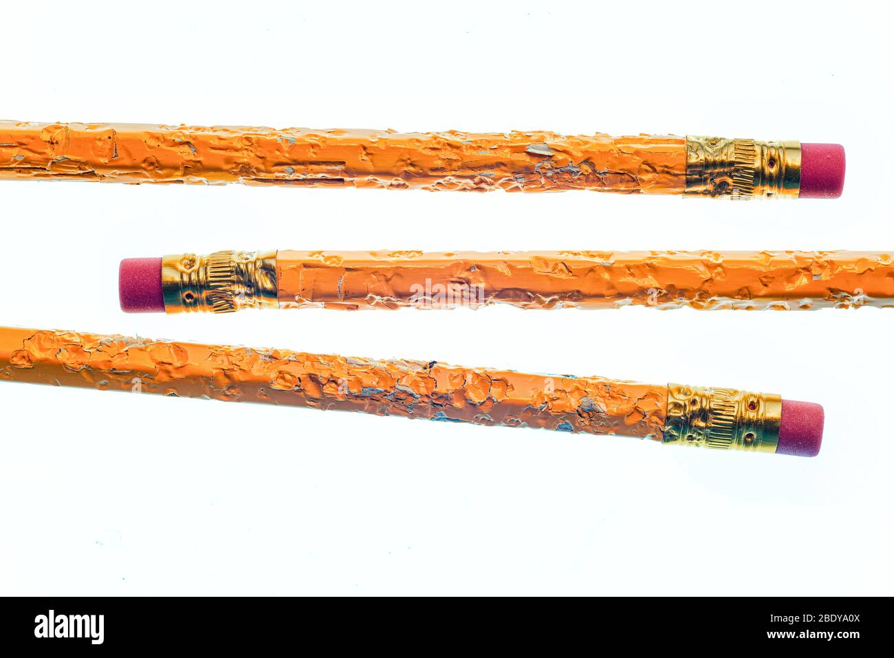 Horizontal shot of the eraser end of three chewed pencils. Two are ...