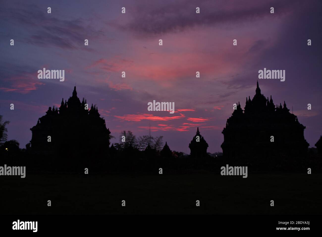 Silhouette of Hindu temple buildings during sunset with purple and red ...