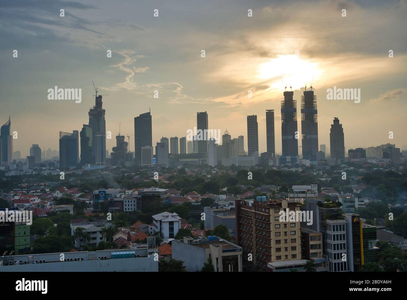 Aerial view of Jakarta city with the skyline and the sun hidden by ...