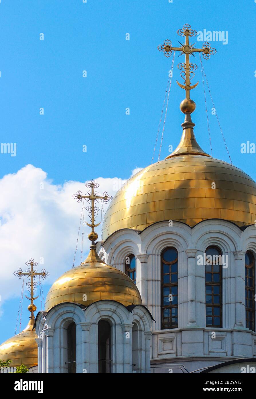 Golden crosses and domes of an orthodox temple against the blue sky ...