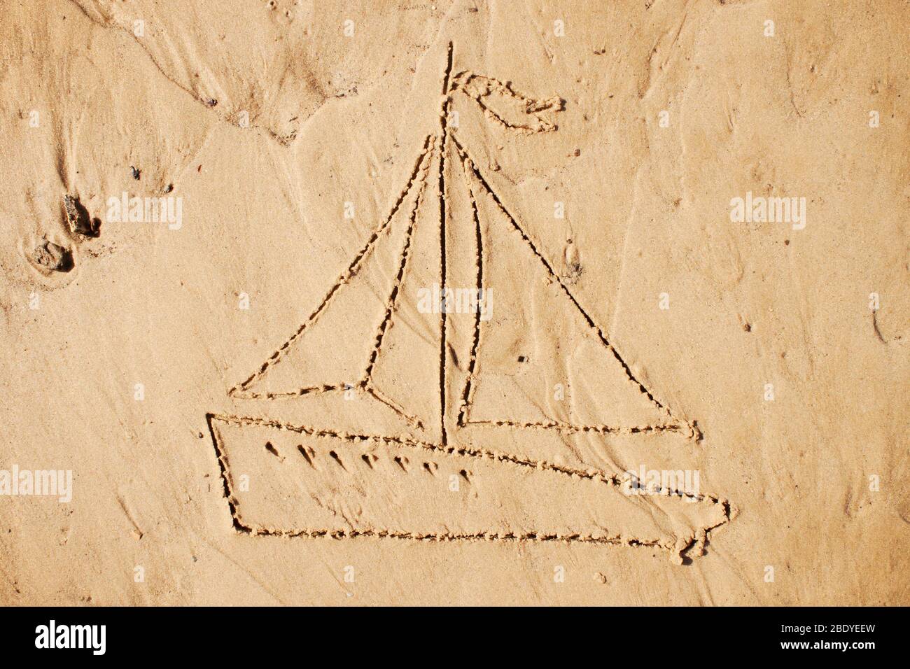 Yacht was depicted in the sand. Drawing on the sandy shore Stock Photo ...