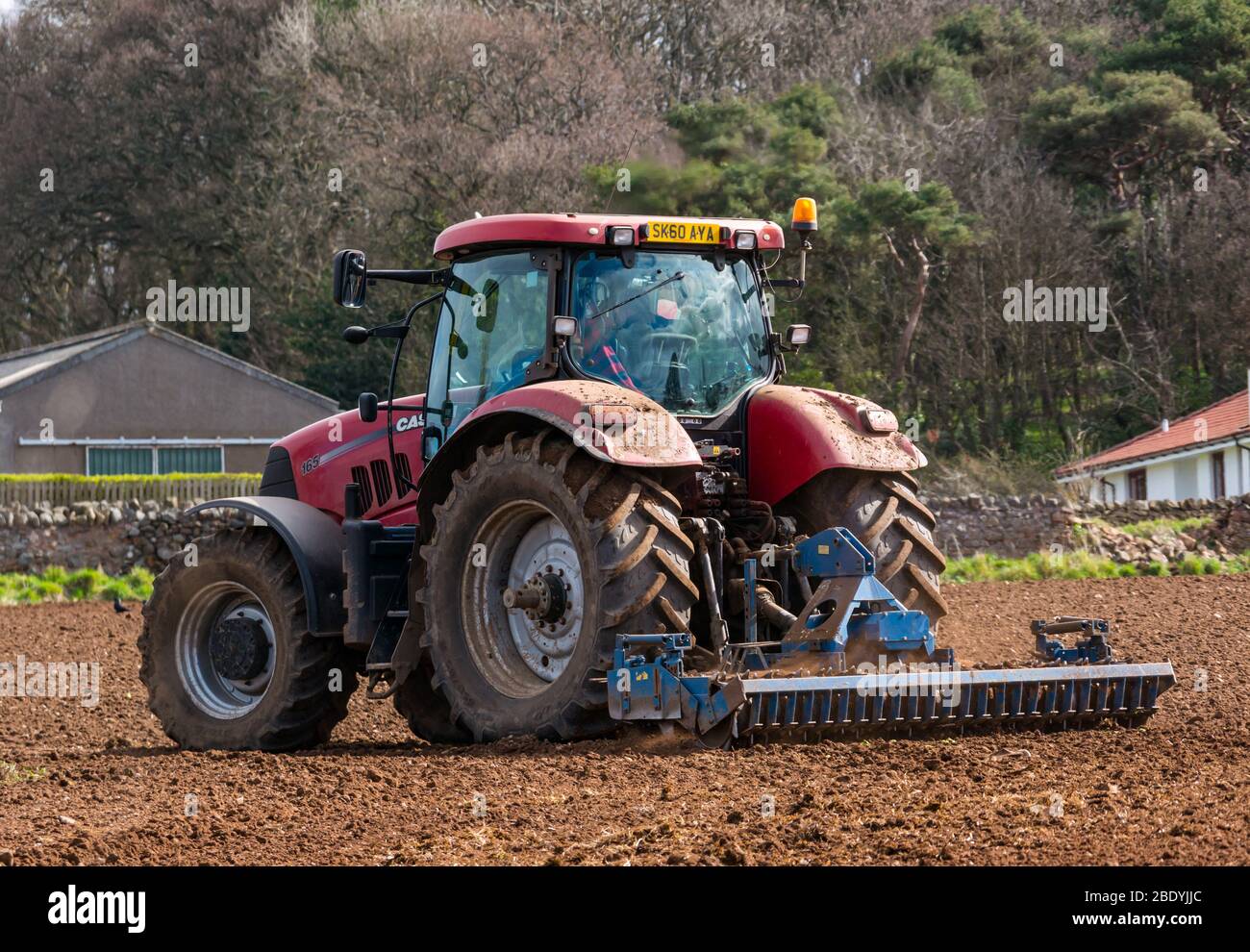 Tractor in field in arable farming landscape, East Lothian, Scotland ...
