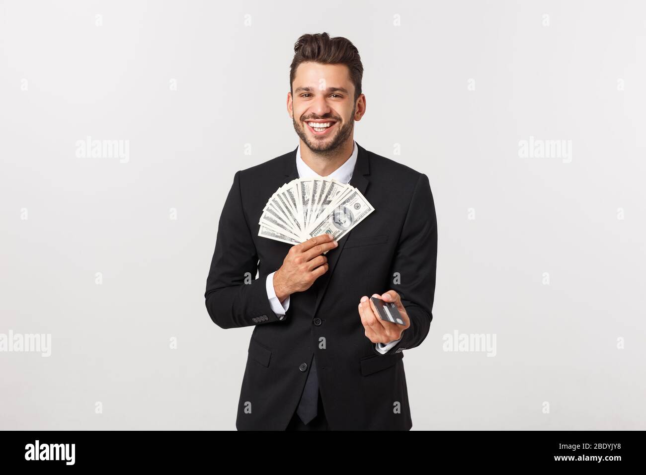 Portrait of a happy smiling man holding bunch of money banknotes and ...