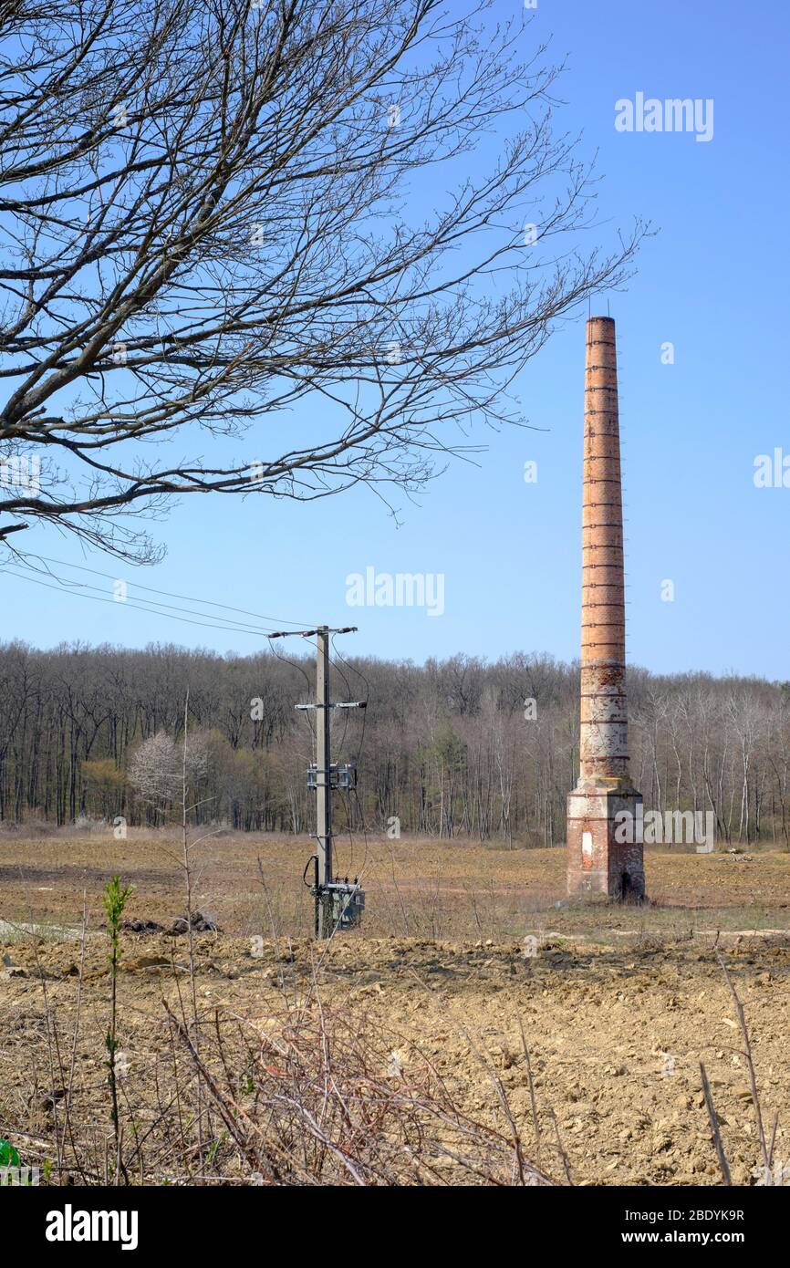 tall industrial chimney stack stands alone in the centre of an empty ...