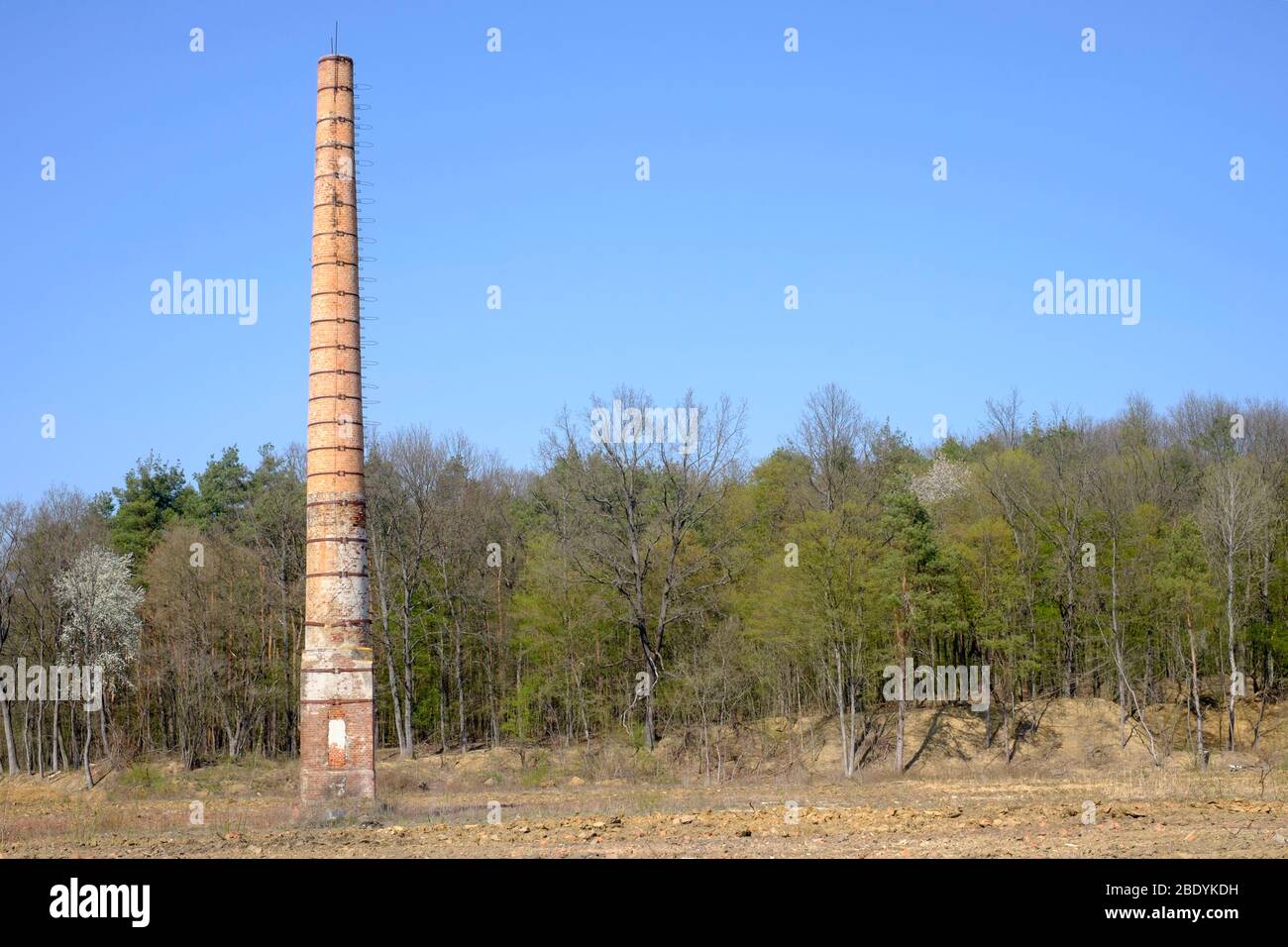 tall industrial chimney stack stands alone in the centre of an empty ...