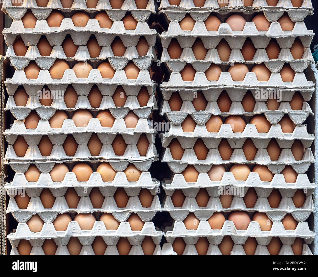Rows of a stack of egg trays. Storage of a large stock of chicken eggs ...