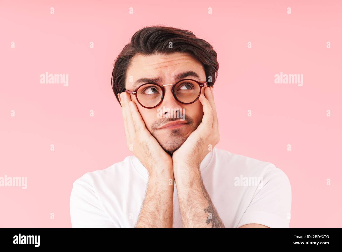 Image of brunette brooding man wearing eyeglasses looking upward at ...