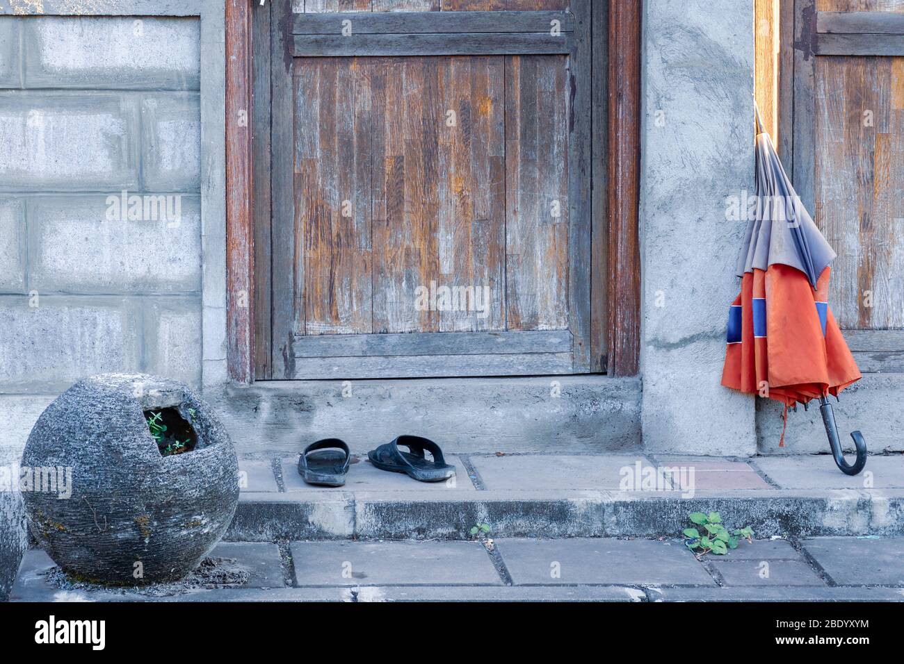 Doorstep of a poor house with a wooden door. View from the bottom angle ...