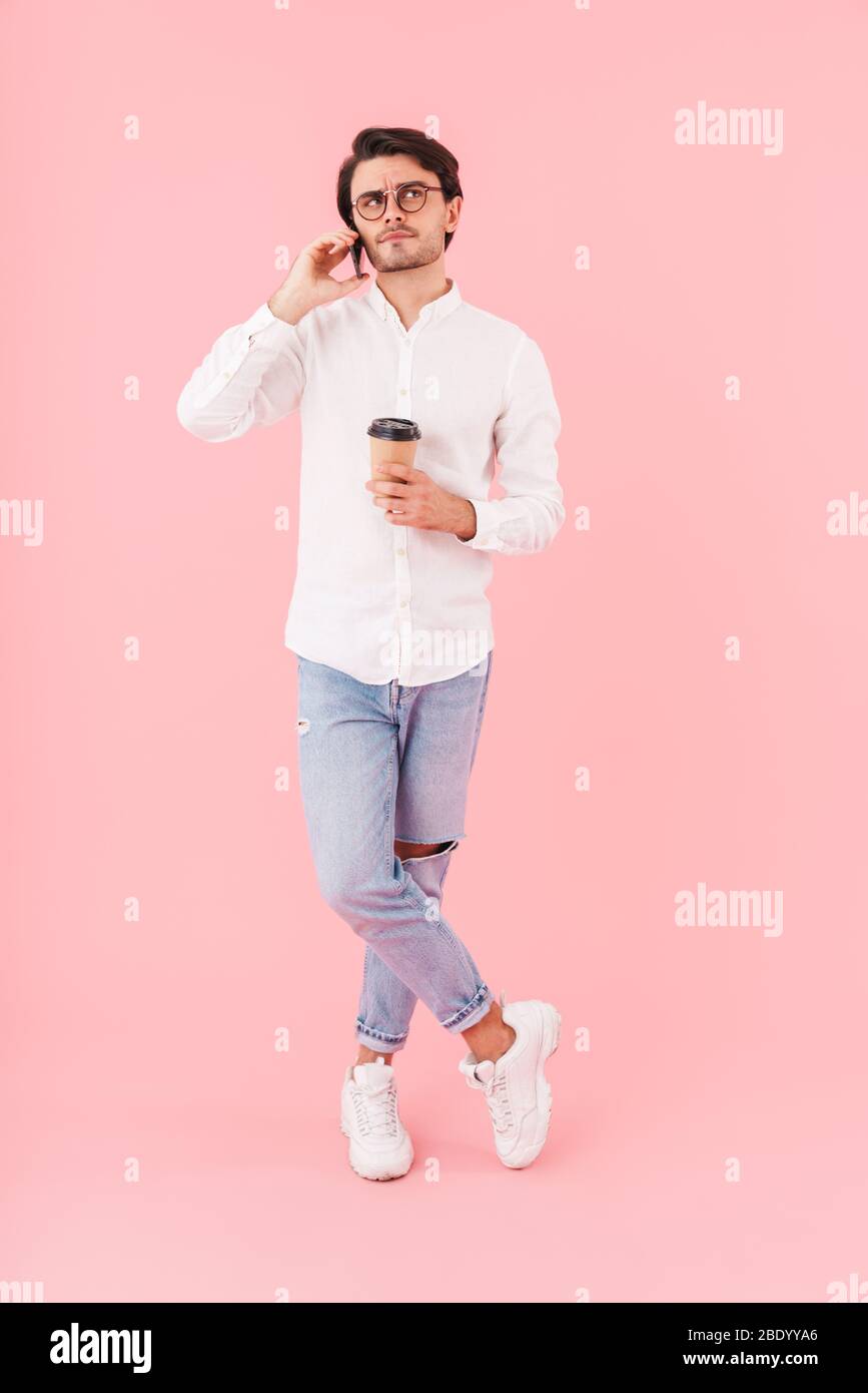 Image of unshaven perplexed man wearing eyeglasses drinking coffee ...