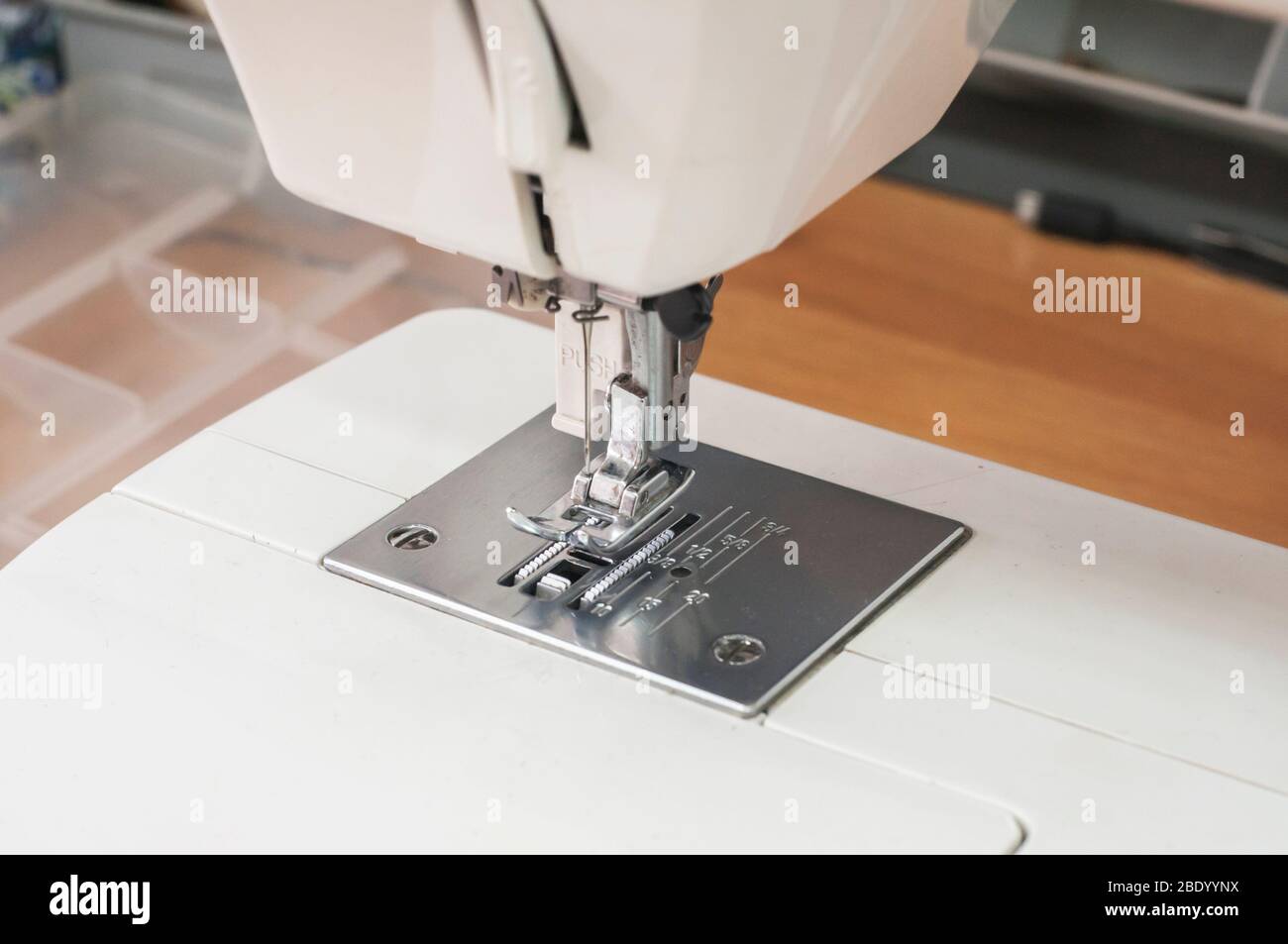 Needle and foot of sewing machine closeup as manufactoring background ...