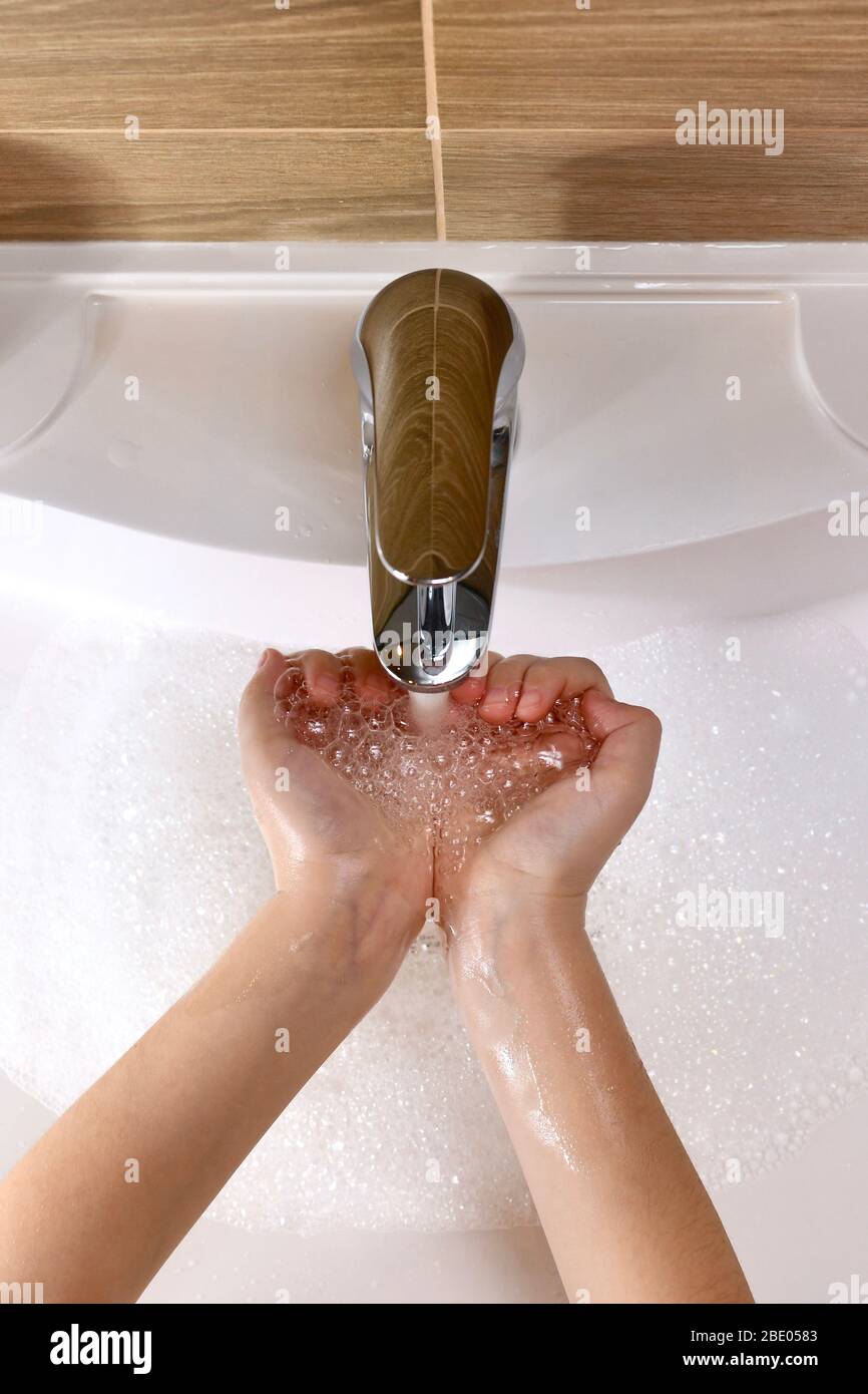 The child folded his palms with his heart and directed under a jet from ...