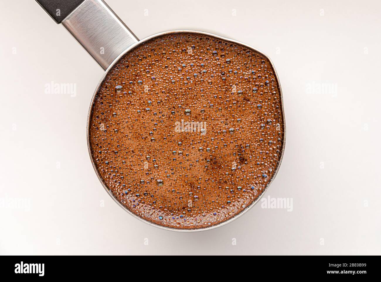 black coffee in turkish coffee pot, top view on white table Stock Photo ...