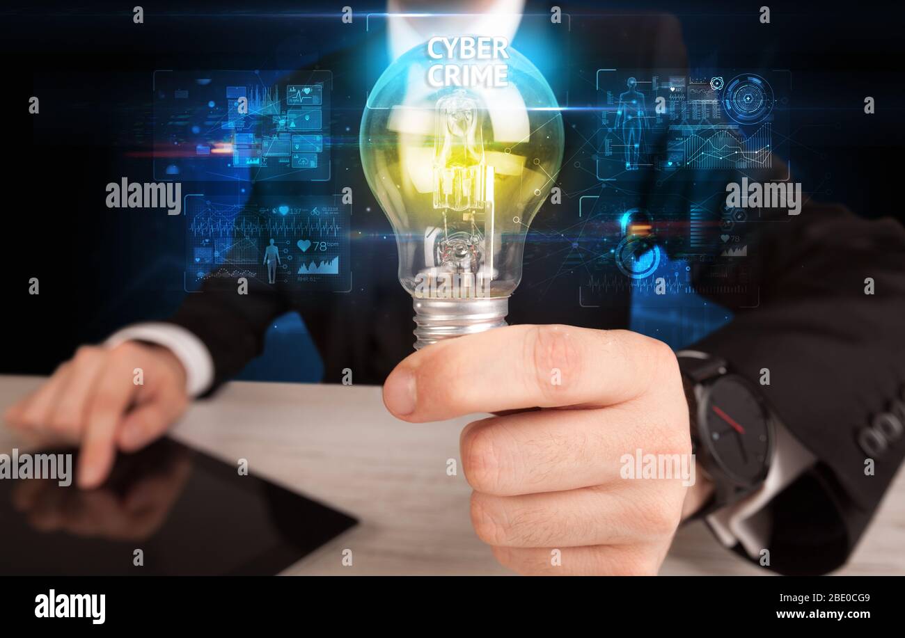 Businessman holding lightbulb with CYBER CRIME inscription, online ...