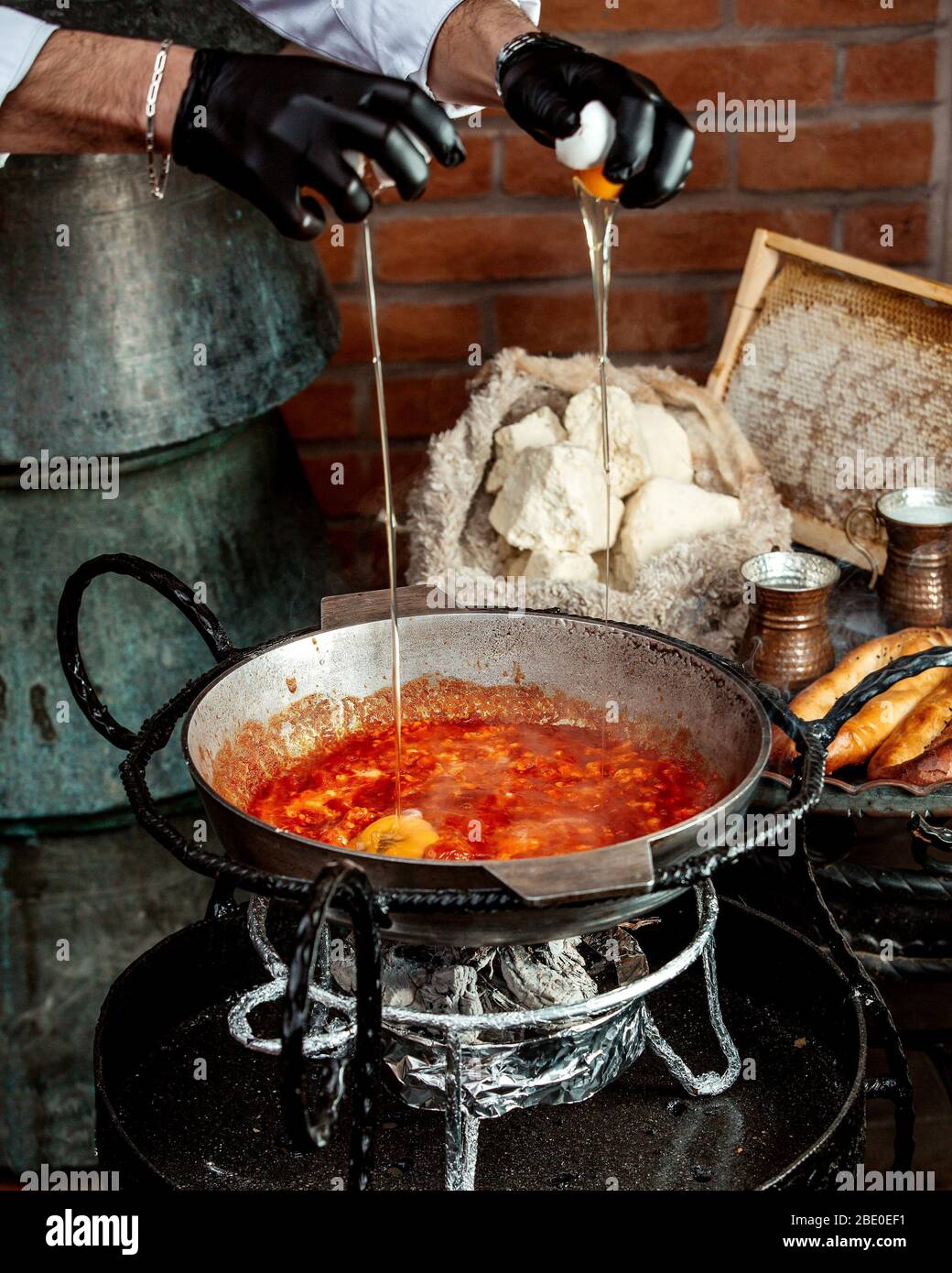 chief pours eggs in tomato omelette Stock Photo - Alamy