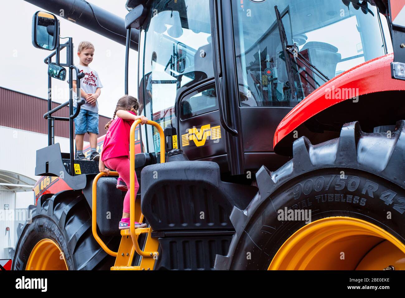 Presentation of new red tractors.New tractor at the exhibition.Children ...