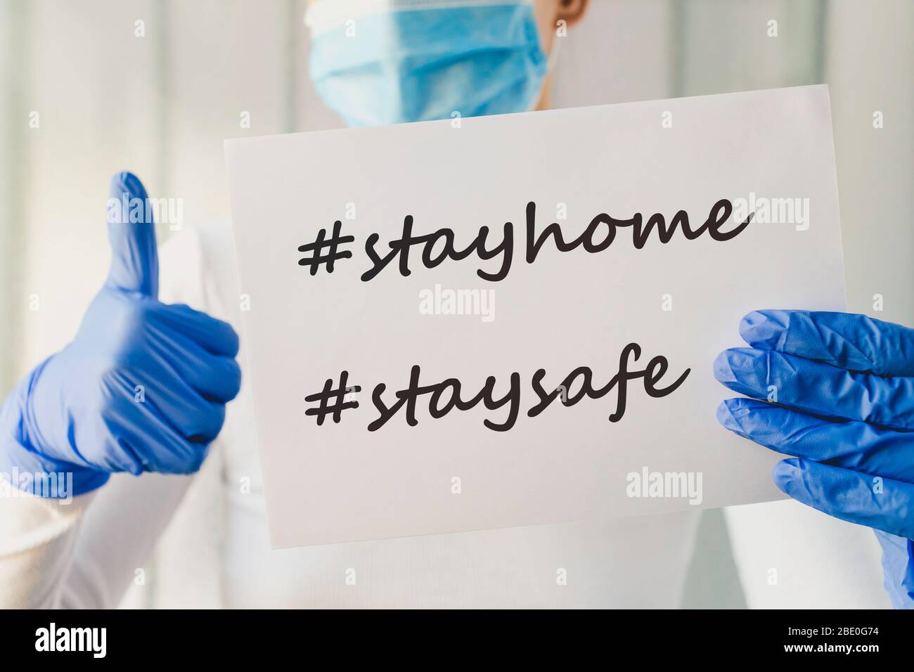 Stay home, stay safe hashtags. Caucasian girl wearing medical mask and ...