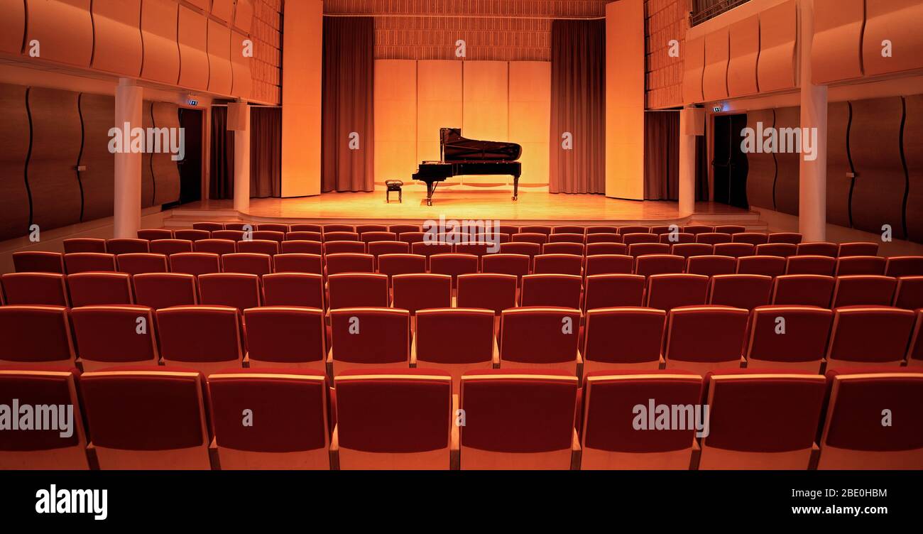 image of a piano on stage inside an empty concert hall Stock Photo - Alamy