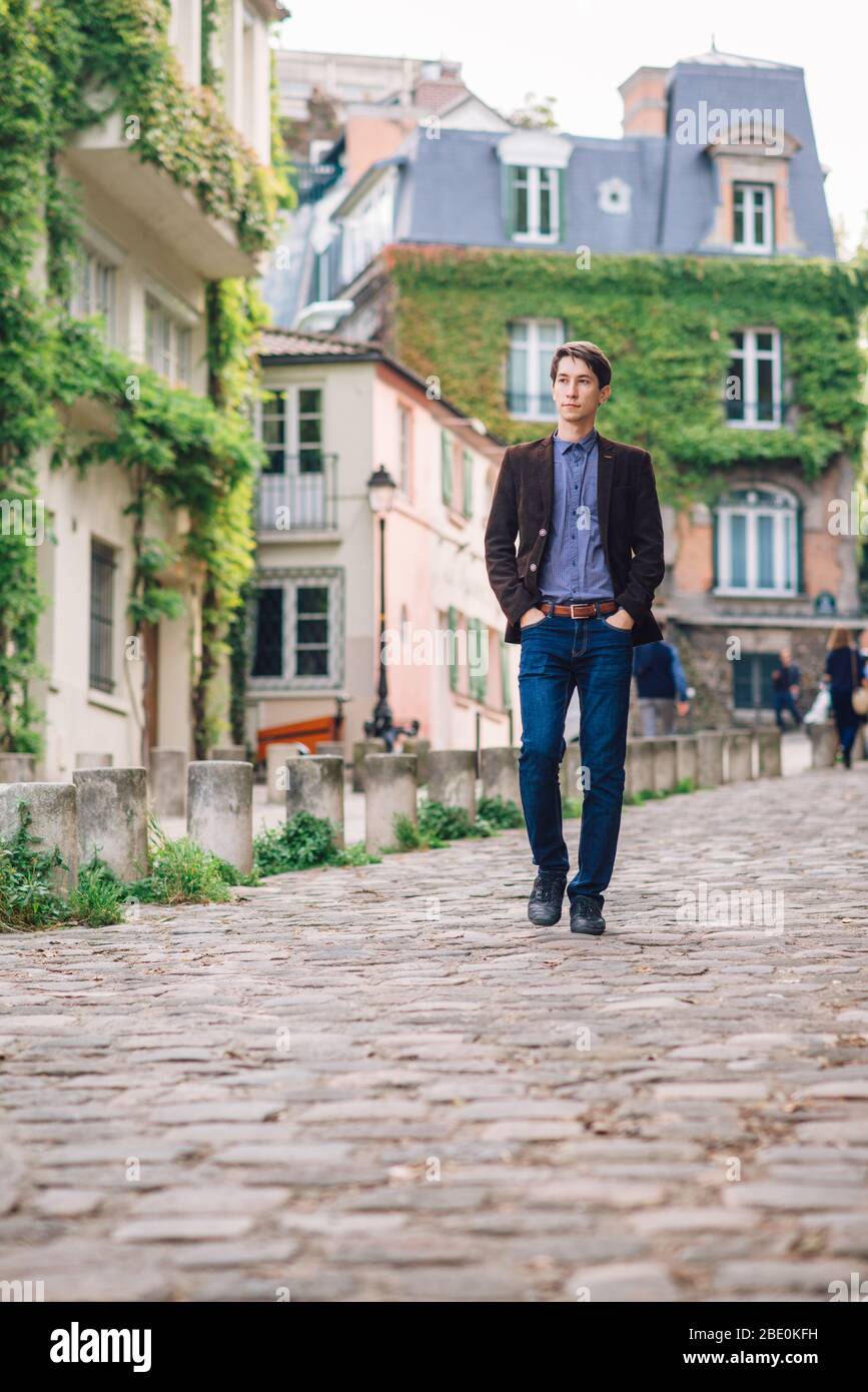 a man in a jacket and jeans walks in Montmartre, Paris, France Stock ...