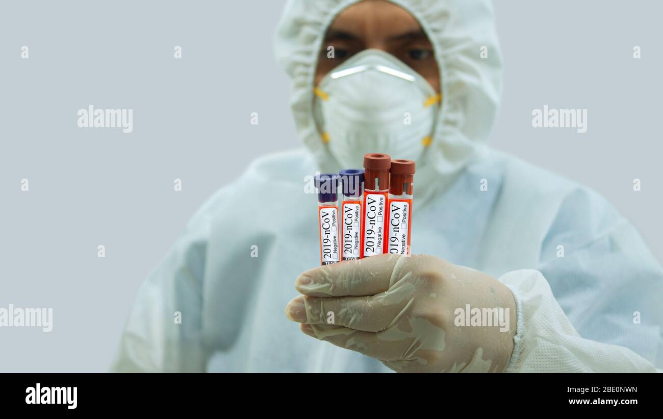 Front view of doctor with mask and bioprotective suit holding with his ...