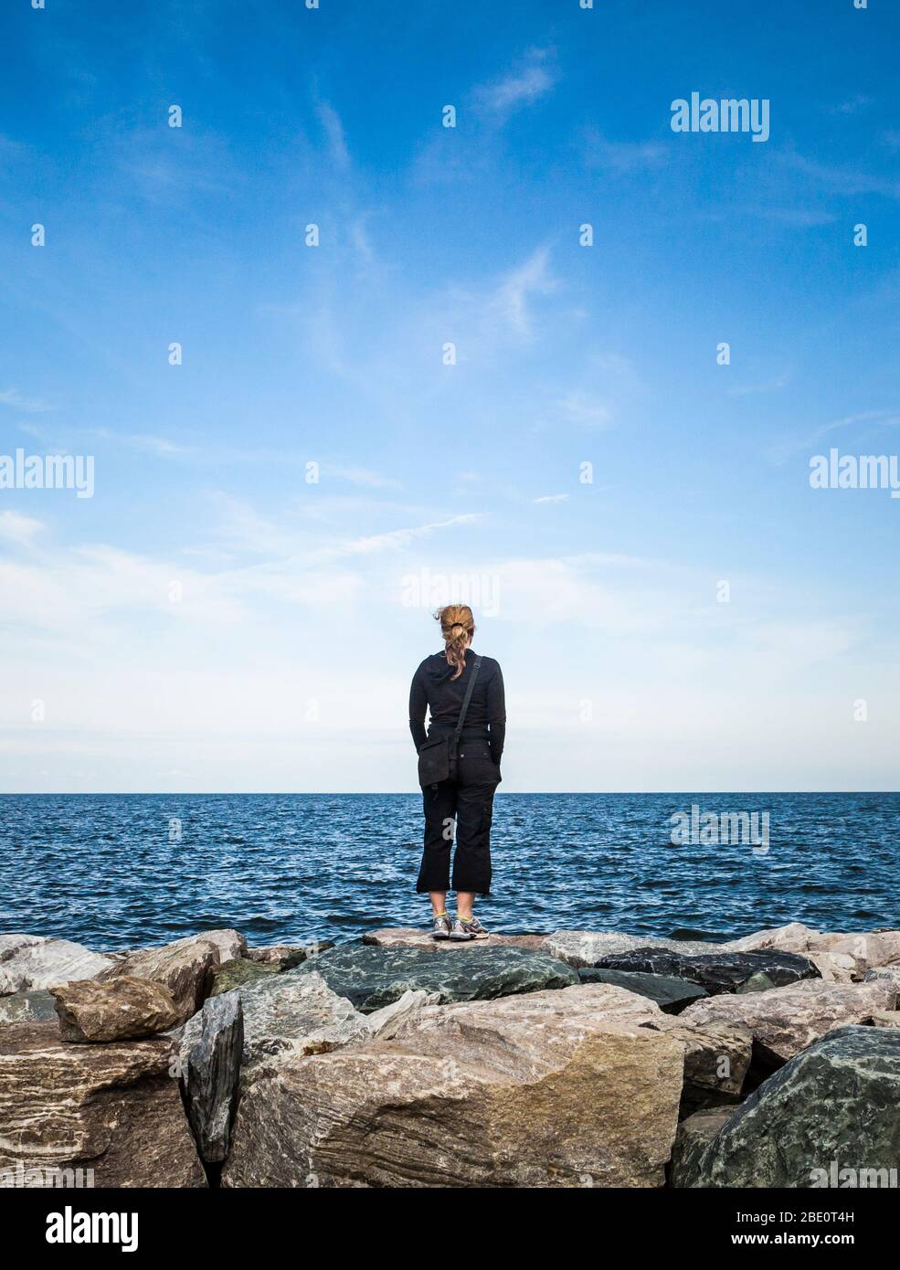 Lone figure looking out to sea hi-res stock photography and images - Alamy