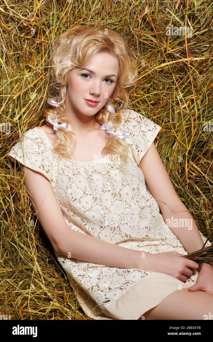 portrait of beautiful blonde country girl sittitng on yellow hay Stock ...