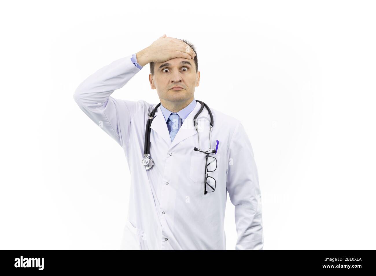 Handsome doctor looks scared and shocked covering forehead with hand ...