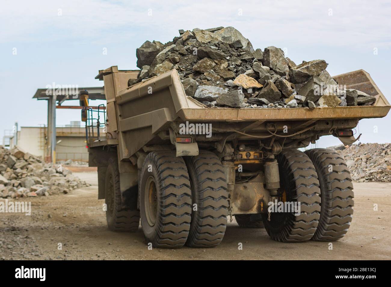 Huge industrial dump truck full loaded back view in stone quarry low ...