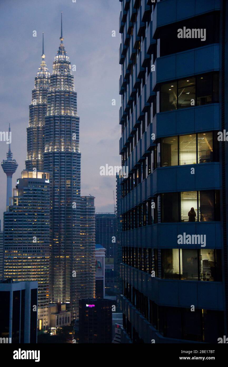 Early evening photo of the Petronas Towers with an office building and ...