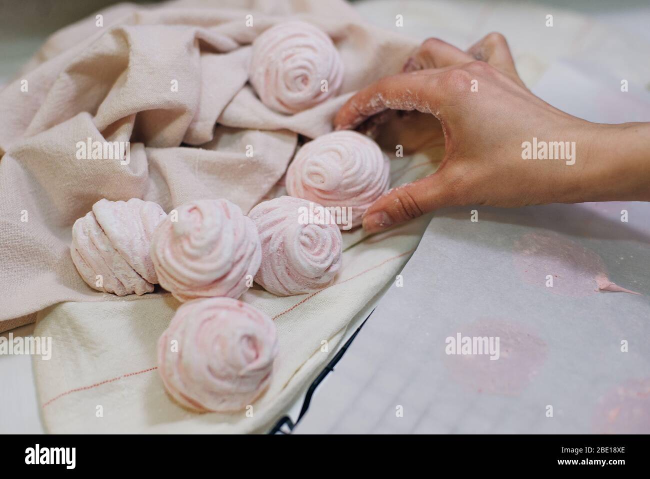 Homemade pink marshmallows on baking paper background on the kitchen ...