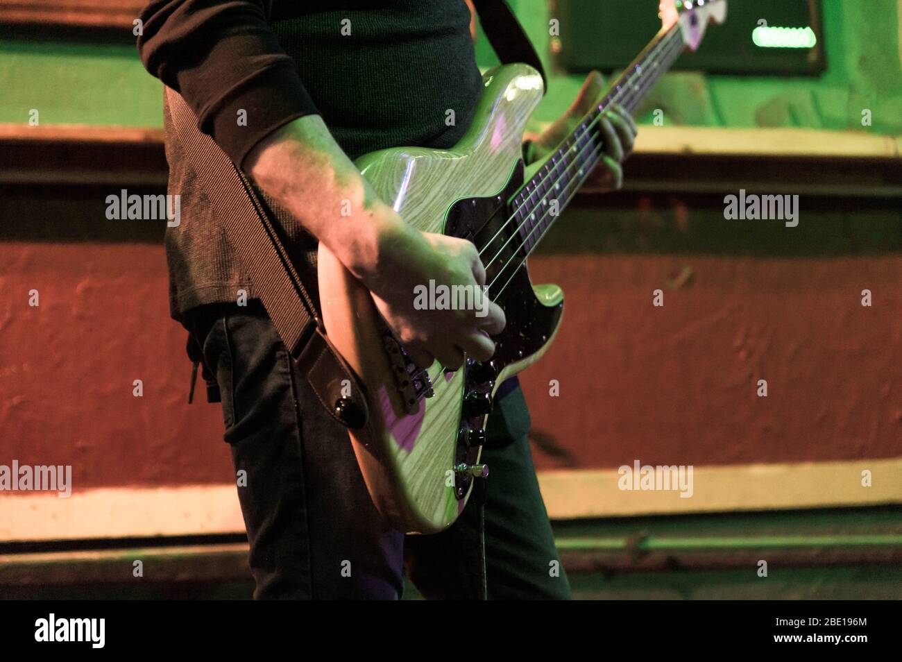 Rock musician at a concert in a small venue playing the bass, New York ...