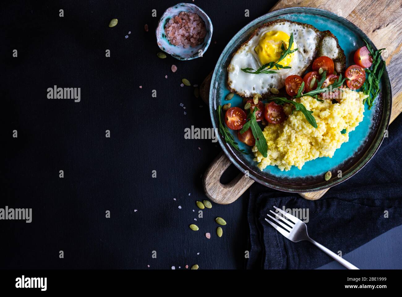 Healthy breakfast concept with millet, fried egg and cherry tomato with ...