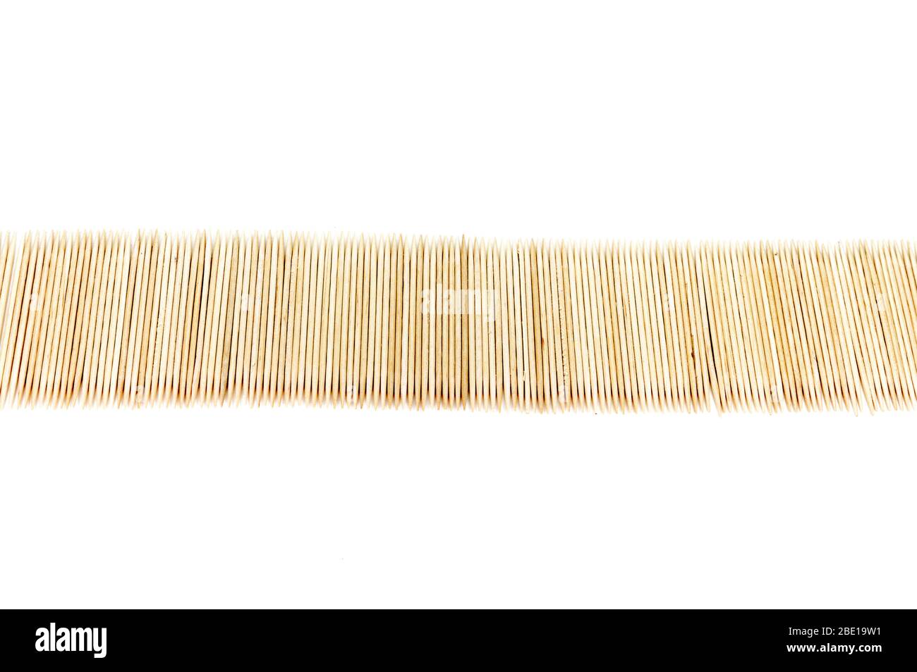 Large number of toothpicks lined up in a long row, isolated on a white ...