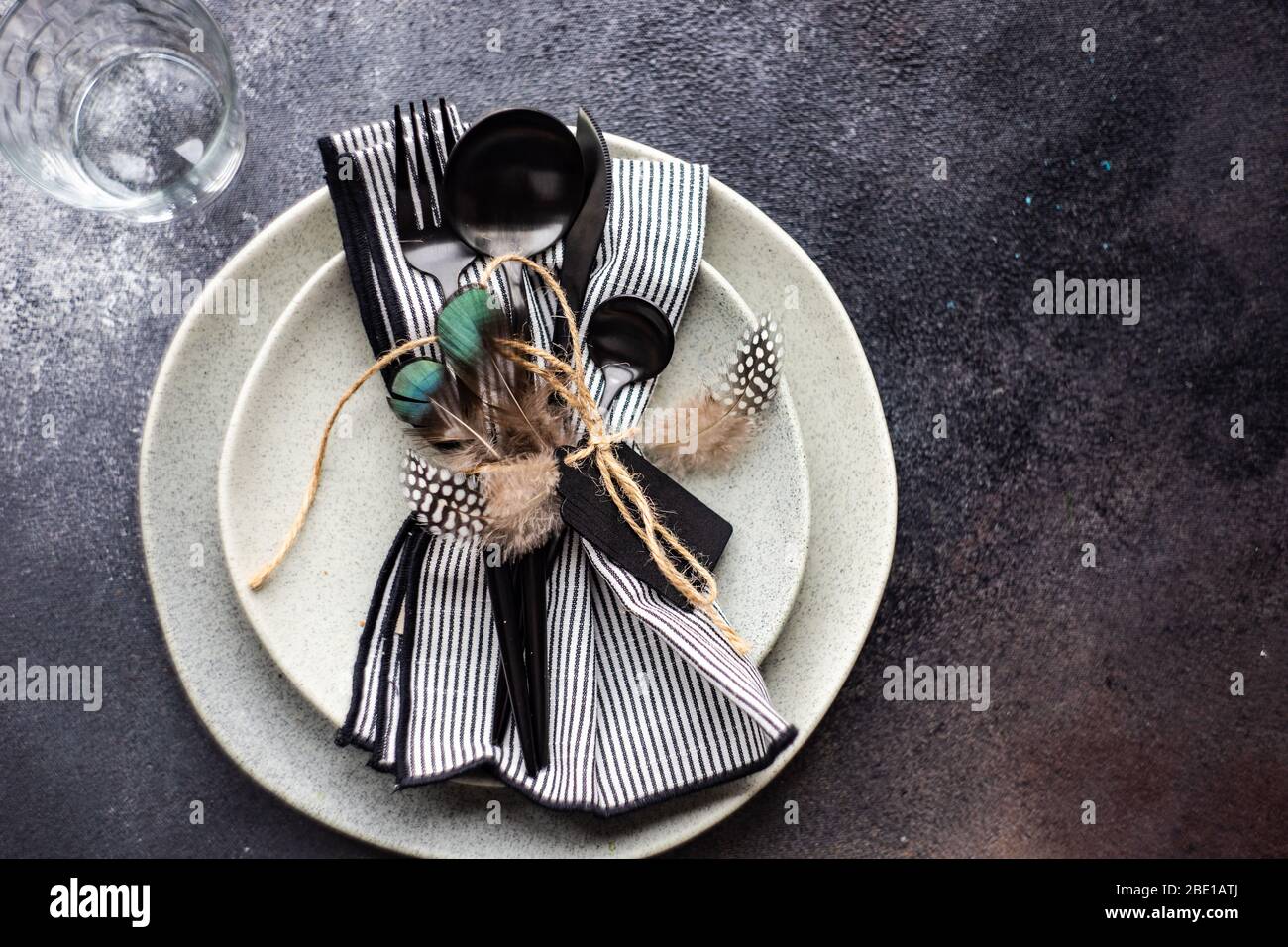 Table setting with cutlery and napkin on concrete background with copy ...