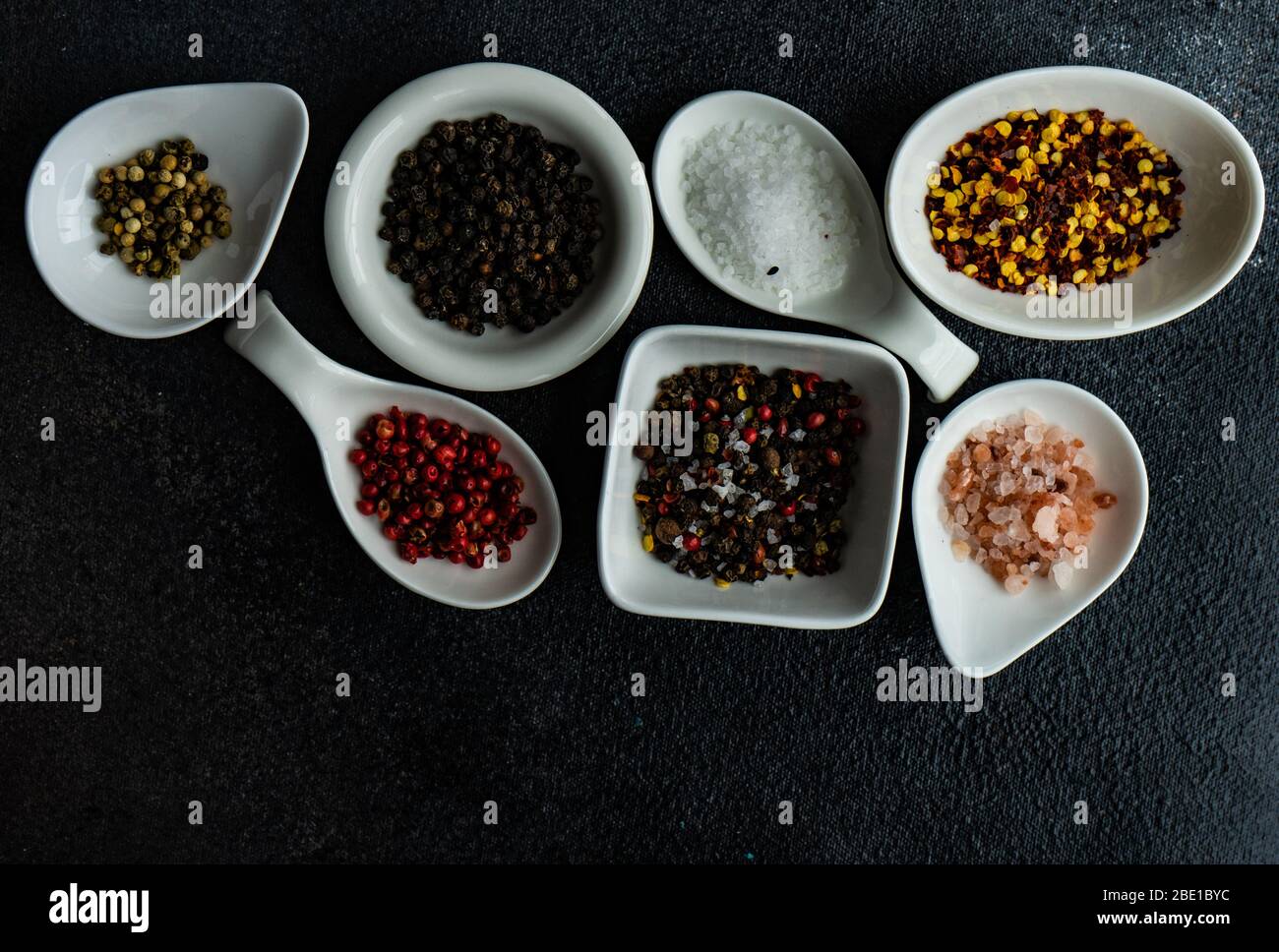 Various types of pepper spice in bowls on concrete background with copy ...