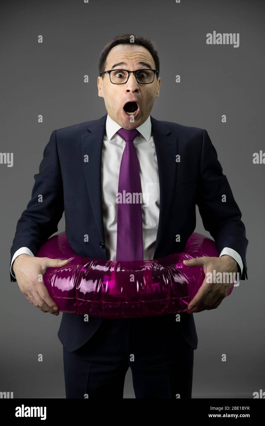 Shocked male business owner in formal clothes and lifebuoy feeling ...