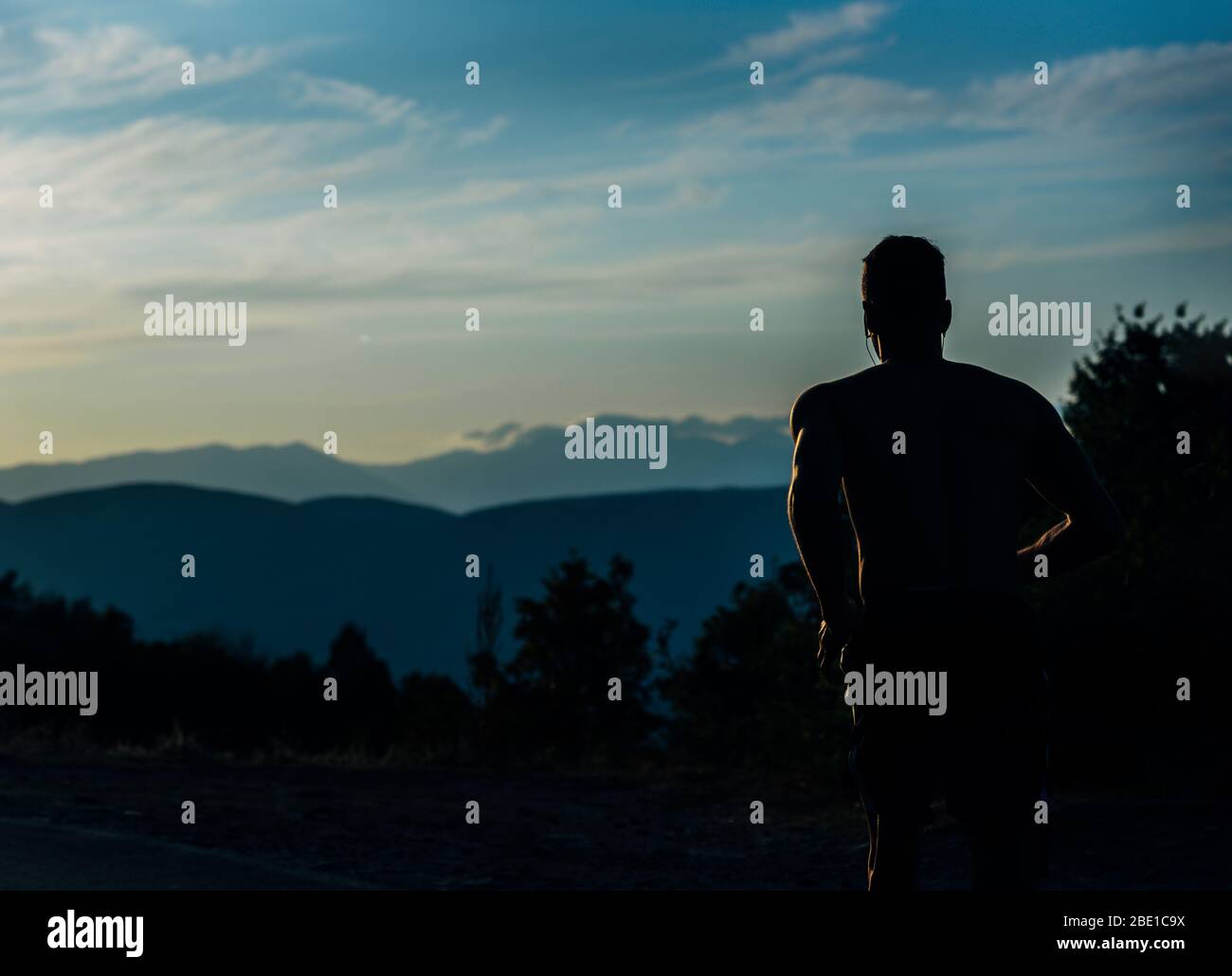 Sweaty man running on rural road. Hispanic male athlete training and ...