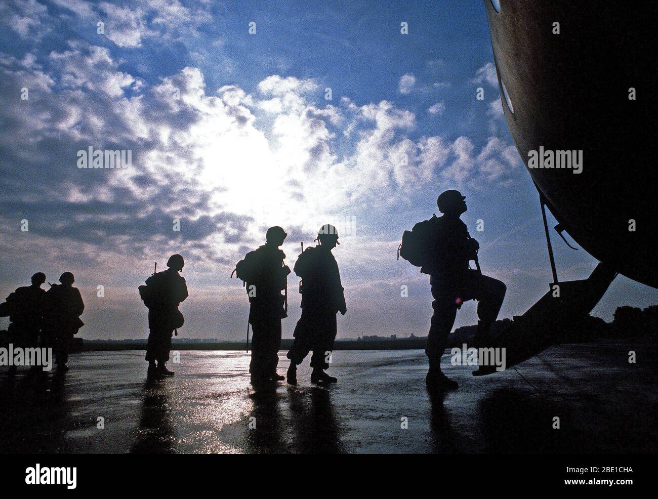 Silhouette view of members of the 16th Signal Battalion embarking on a ...