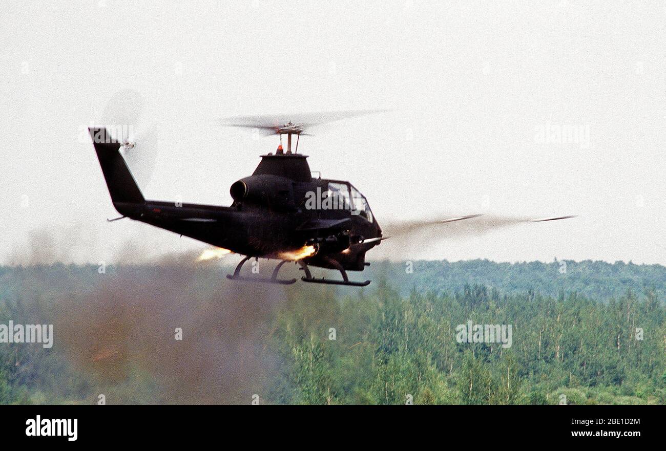 A right rear view of an AH-1 Cobra helicopter launching missiles for a ...