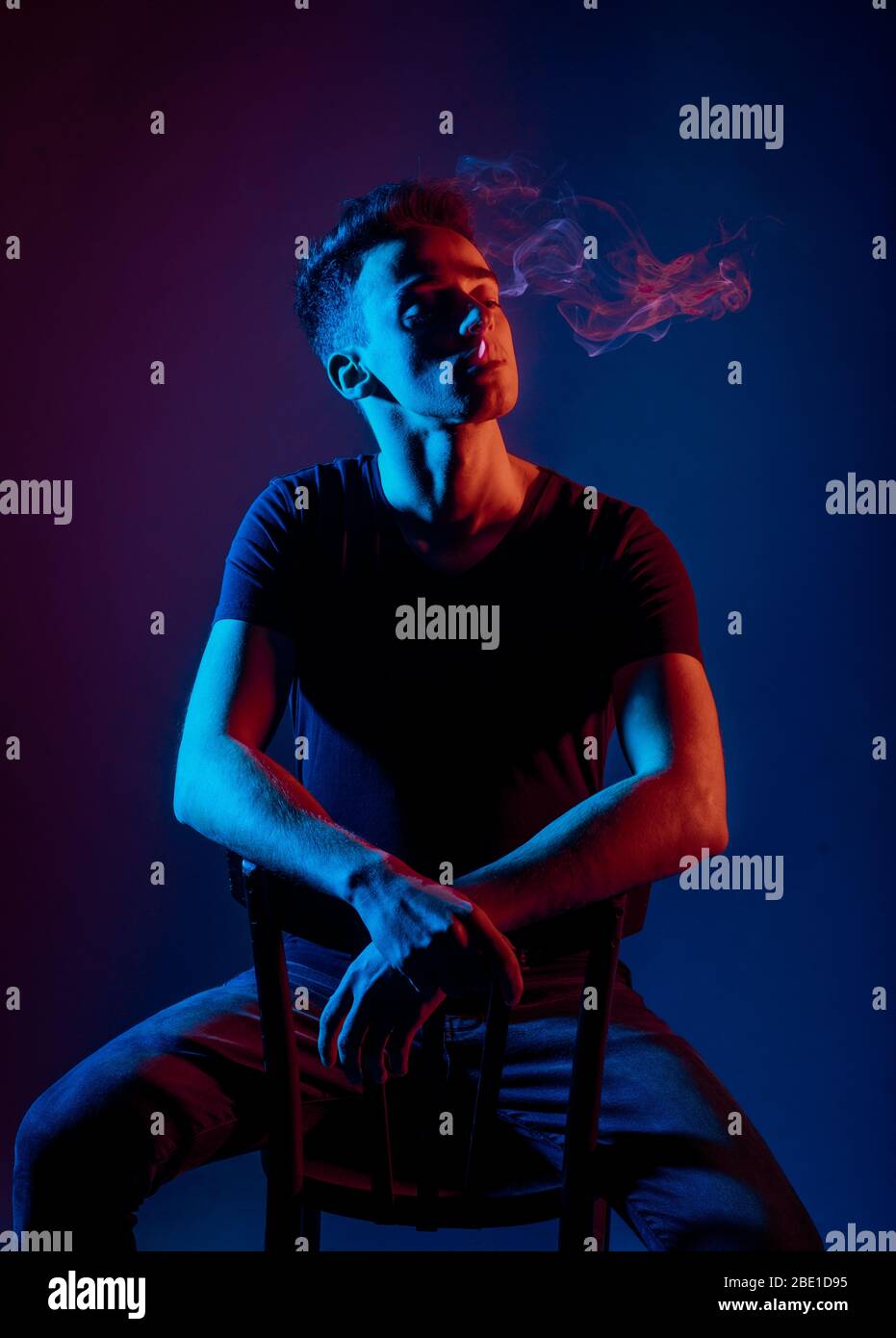 Portrait of a handsome skinny man posing against colorful background ...