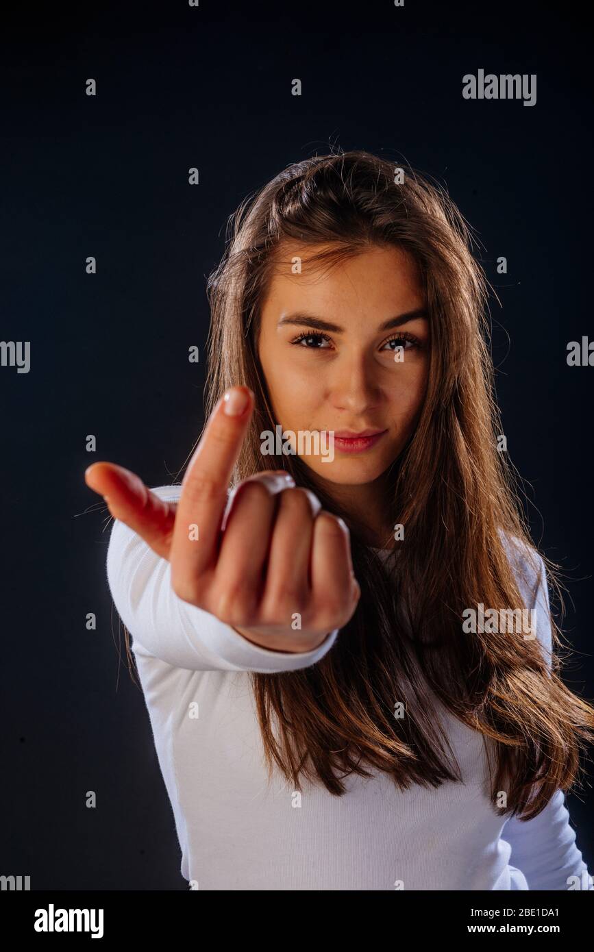 Handsome female model pointing at you while standing in front of a ...