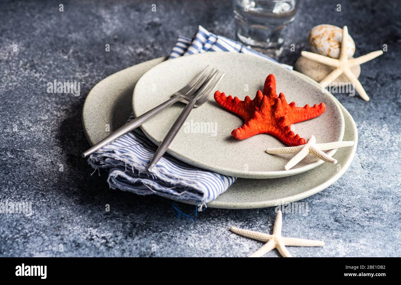 Summer table setting with plates and cutlery decorated with sea stars ...