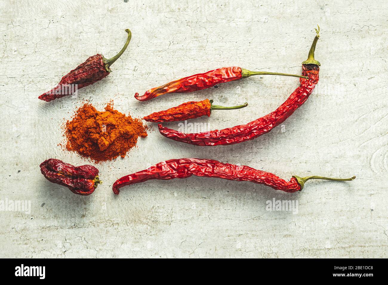Dried red chili peppers and chili powder spice on kitchen table. Top ...
