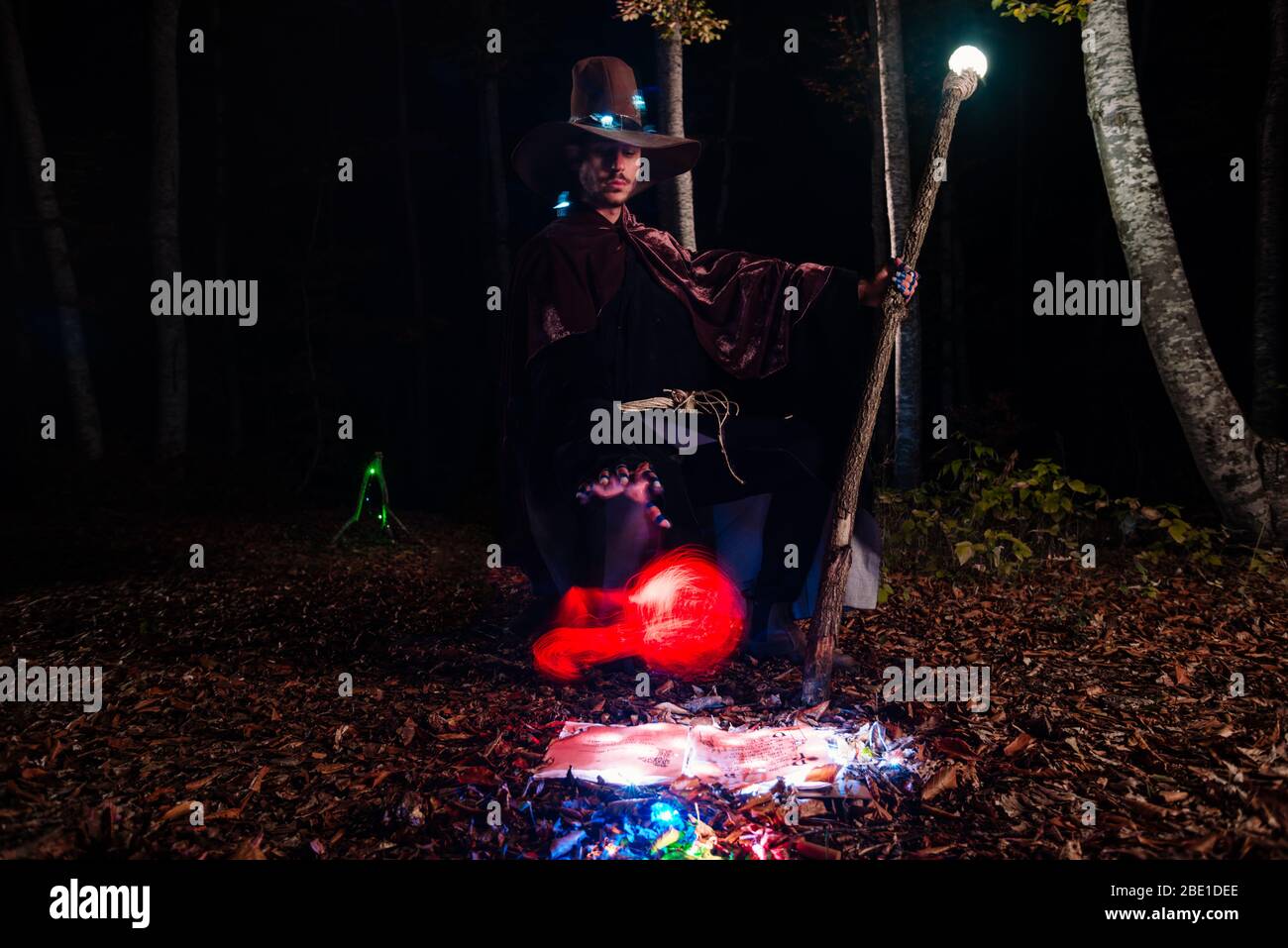 Wizard (mage) casting a spell with his magical staff while standing in ...