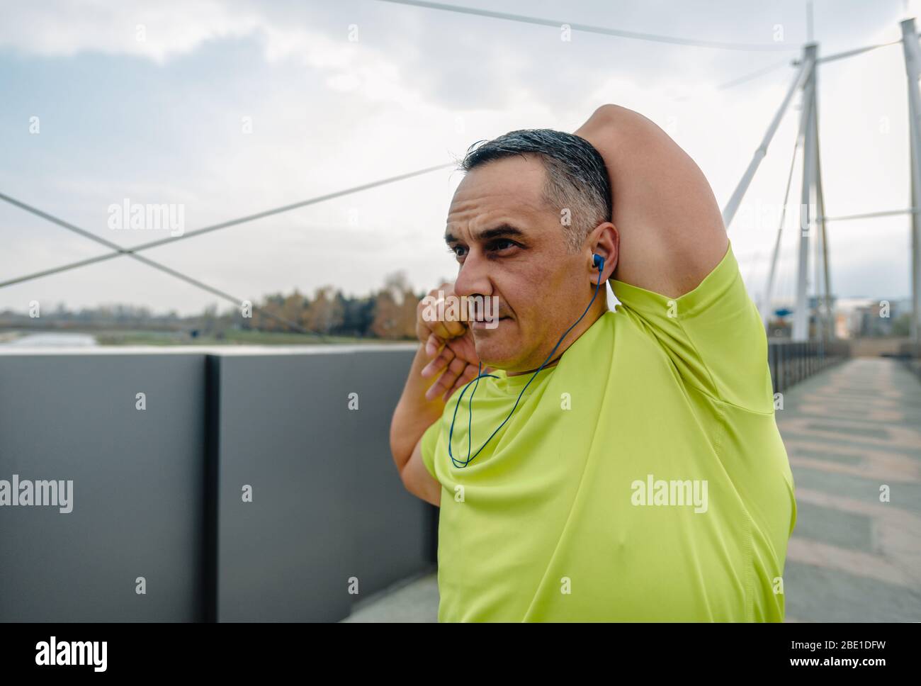 Healthy fit middle aged runner during a warm up routine before running ...