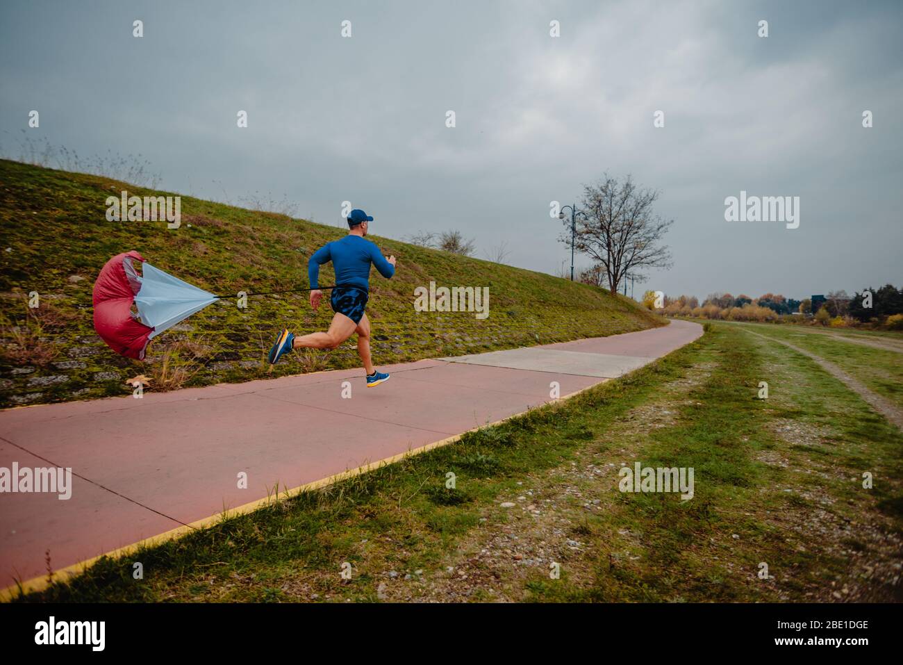 Older well built man in activewear running with a speed parachute Stock ...
